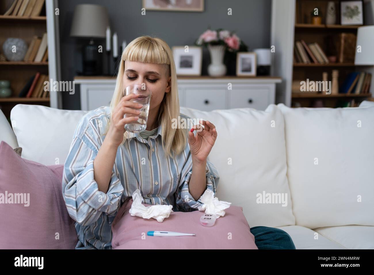 Young sick woman drinking medical pills and water after high body ...