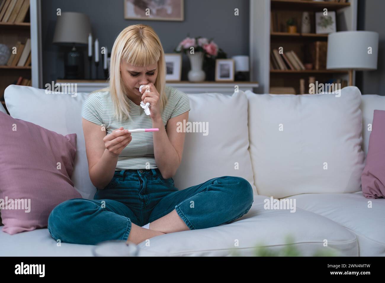 Single sad woman complaining holding a pregnancy test sitting on a ...