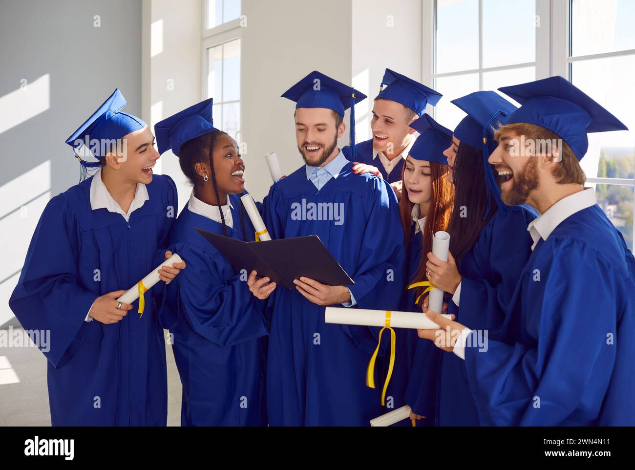 Group portrait of young happy diverse graduate students, celebrating ...