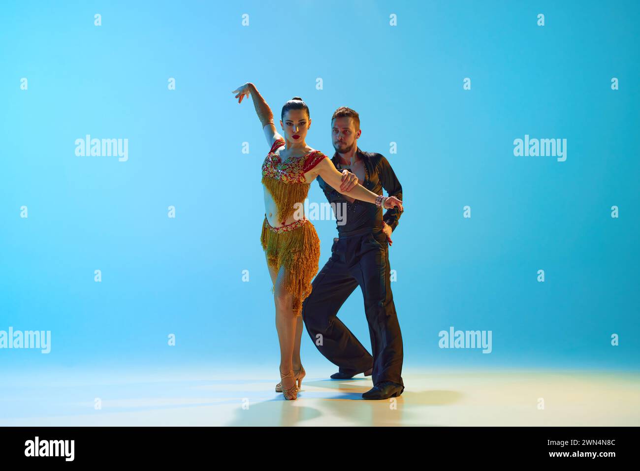Two male and female dancers in a Latin ballroom stance, dancing against ...