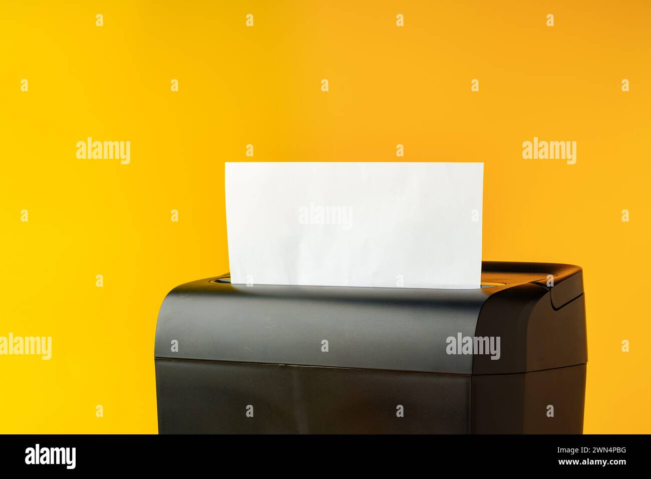 Office paper shredder on yellow studio background Stock Photo - Alamy