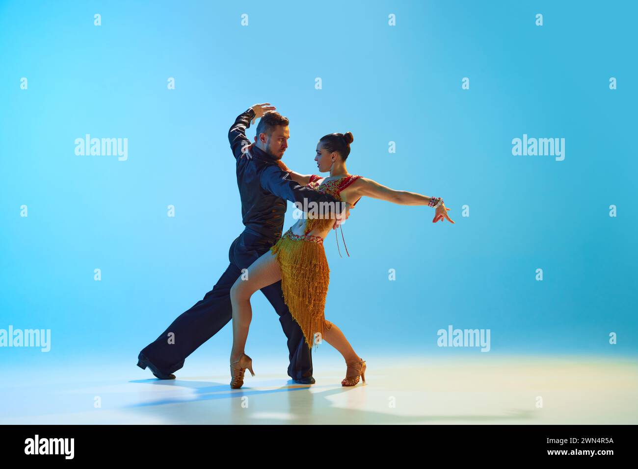 Two male and female dancers in a Latin ballroom stance, dancing against ...