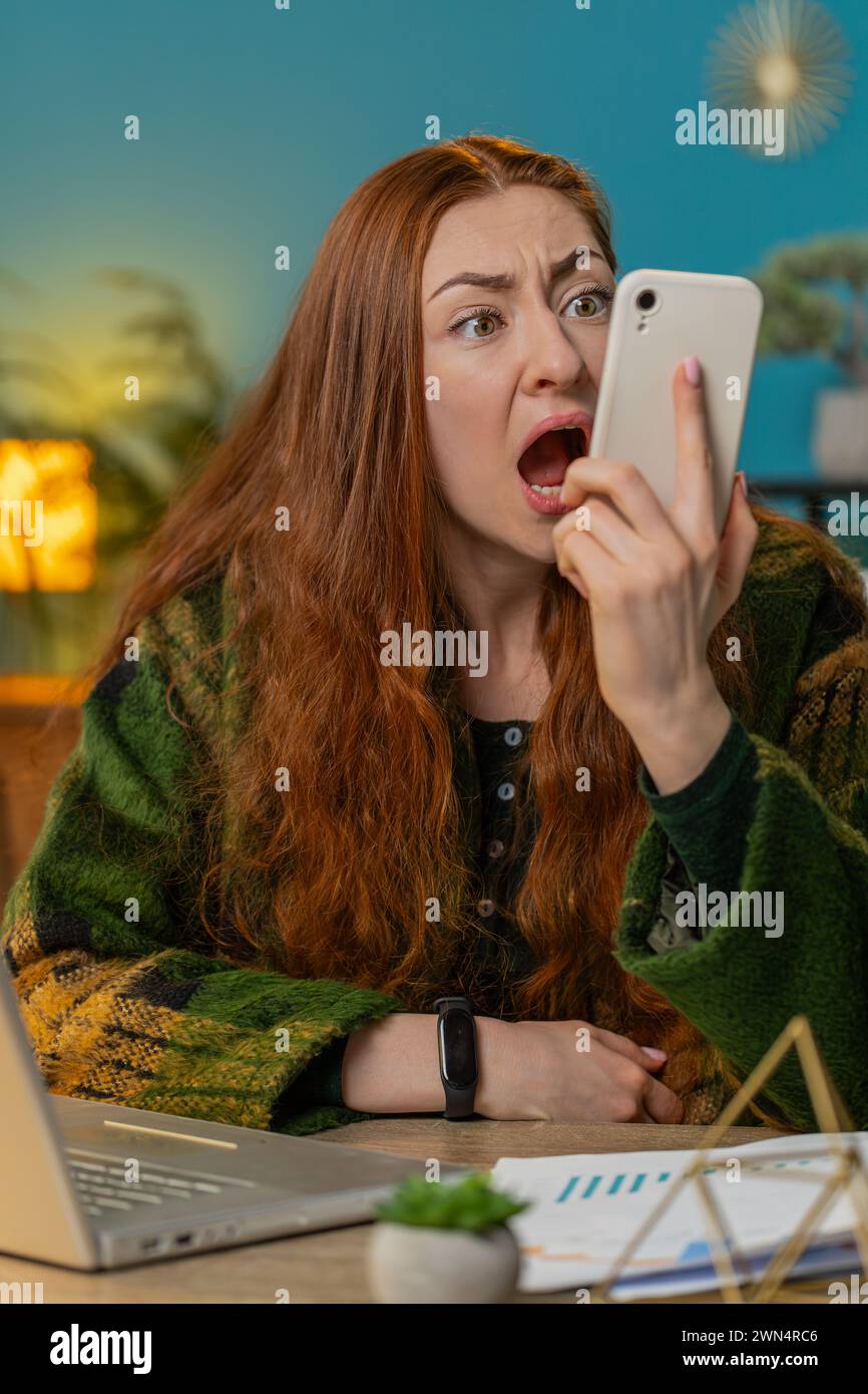 Nervous angry female manager quarrelling smartphone call online at home ...