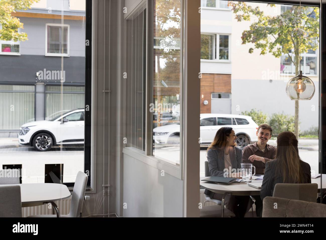 Happy customers discussing with female real estate agent at office ...