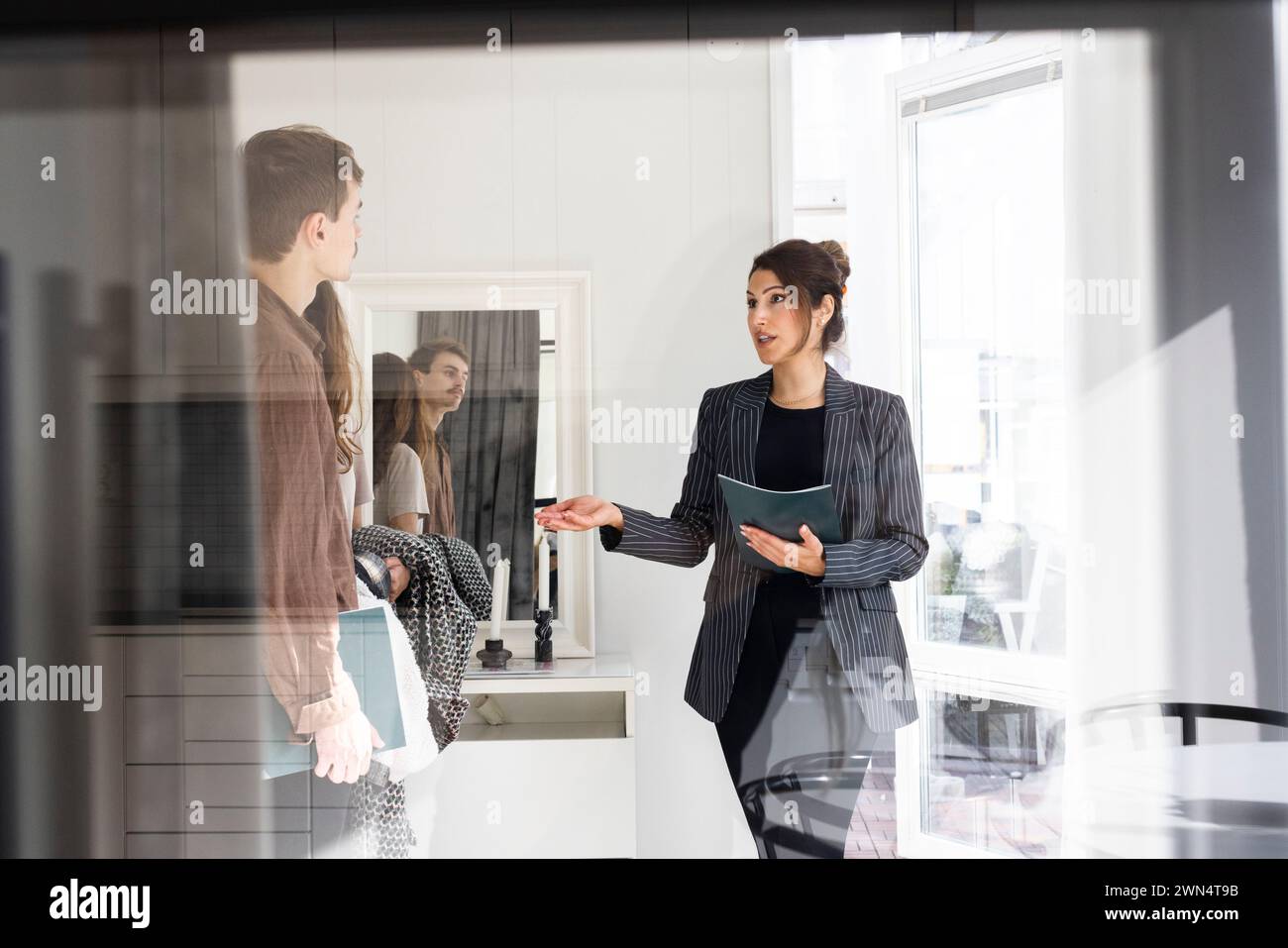 Saleswoman discussing with customers during house visit Stock Photo - Alamy