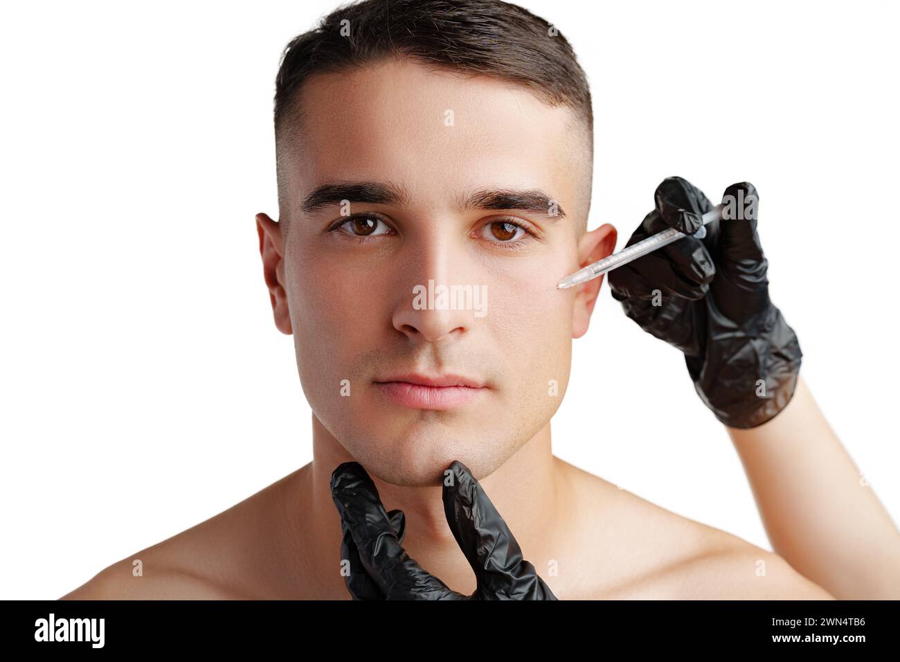 Handsome young man face and beautician hands with syringe making ...