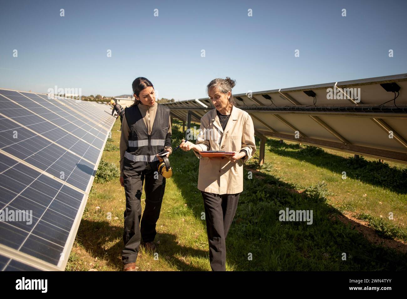 Senior female entrepreneur discussing with engineer while walking near ...