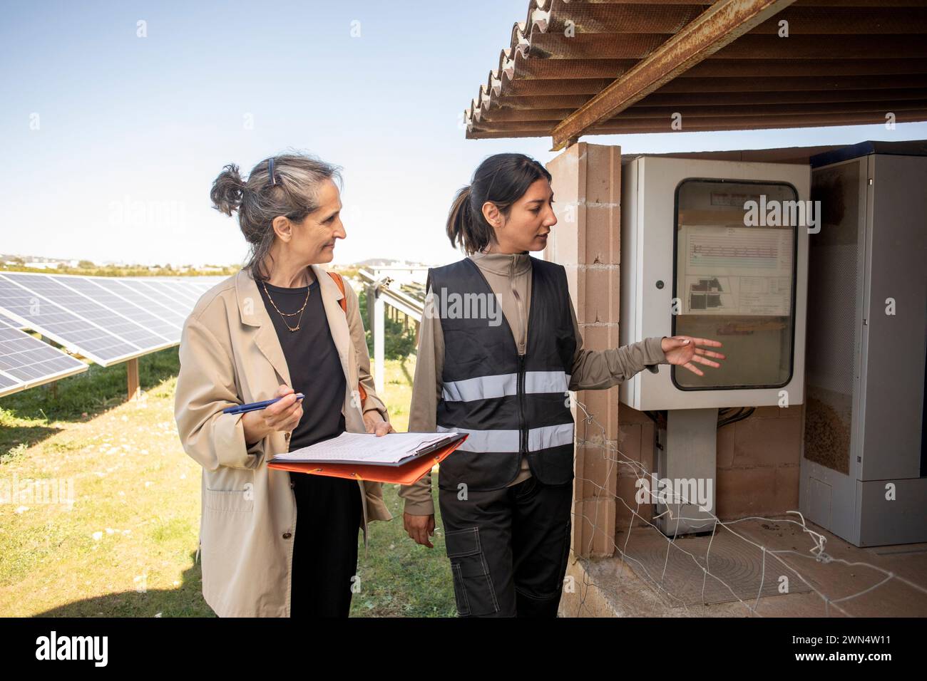 Female engineer explaining circuit board room to senior entrepreneur ...