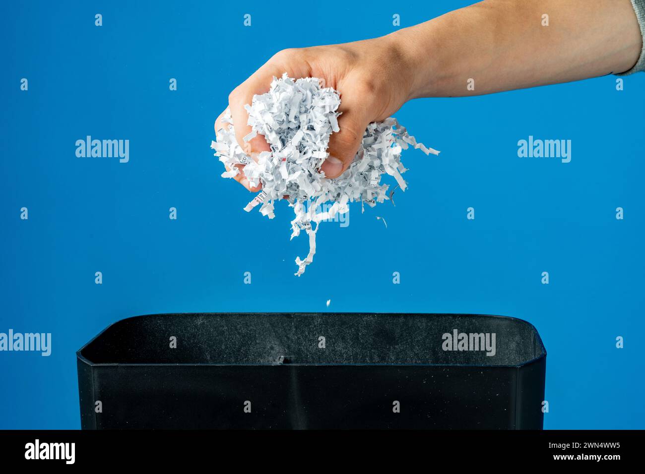 Male hand holding a bunch of shredded paper Stock Photo - Alamy
