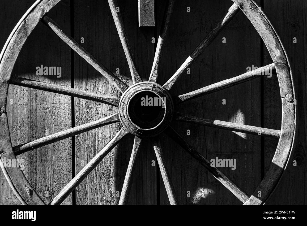 Old wooden wagon wheel hanging on a wall in black and white Stock Photo ...