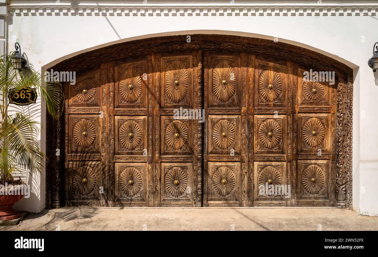 Traditional ornate carved large wooden doors with brass decorations in ...