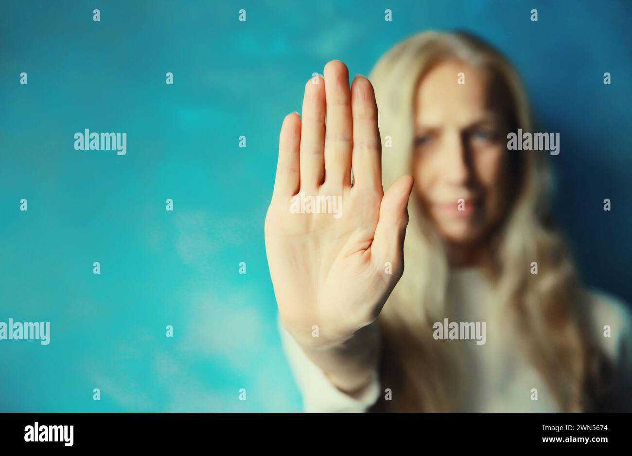 Upset young woman shows stop, no or enough sign with palm of hand ...