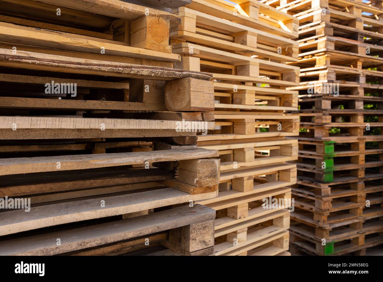 Piles of stacked natural wooden shipping pallets. Outside a big stack ...