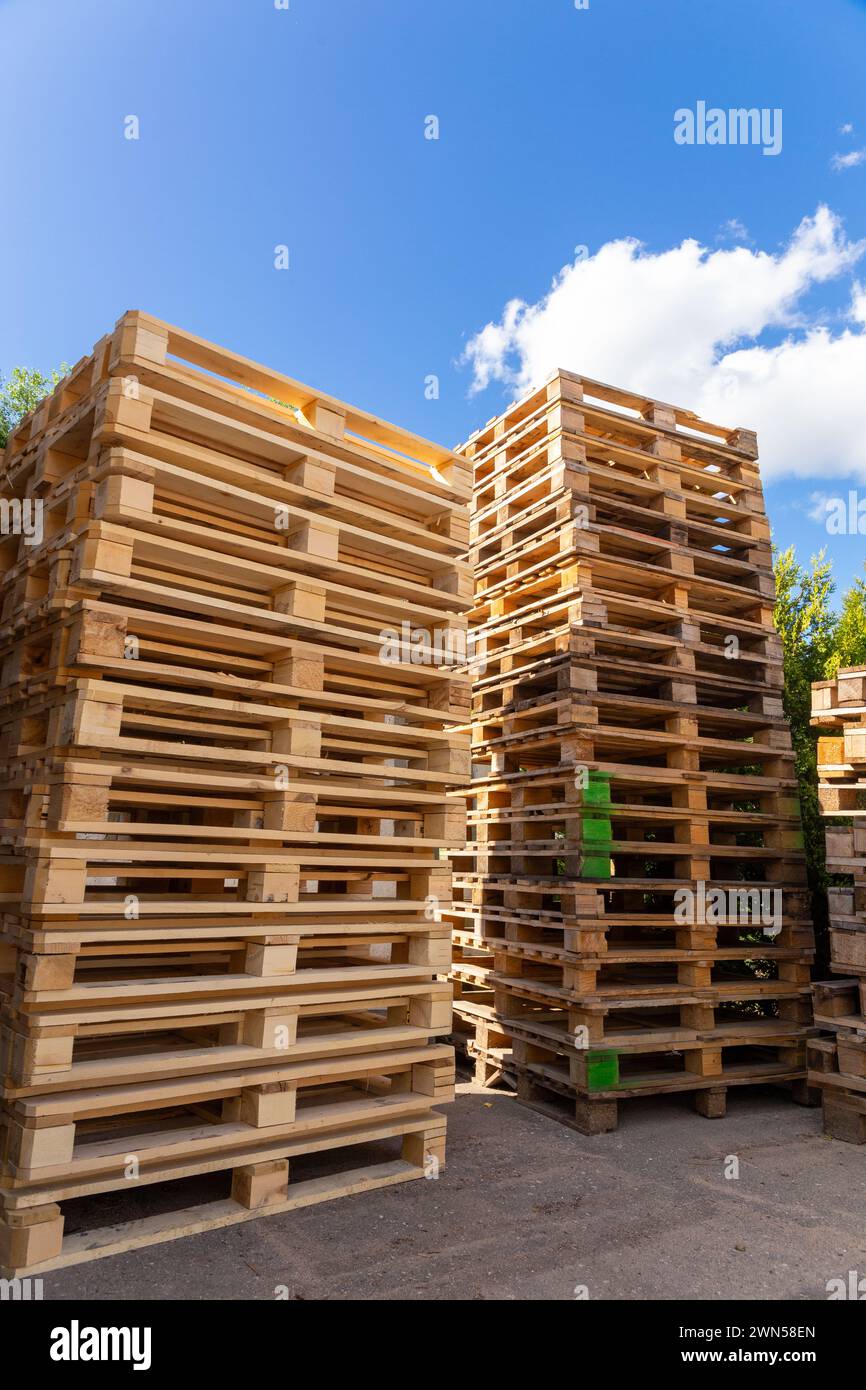 Piles of stacked natural wooden shipping pallets. Outside a big stack ...