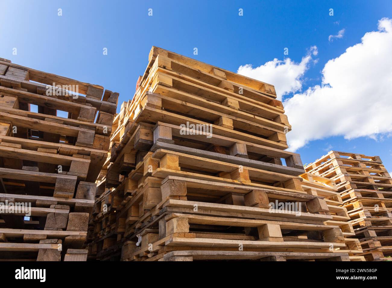 Piles of stacked natural wooden shipping pallets. Outside a big stack ...