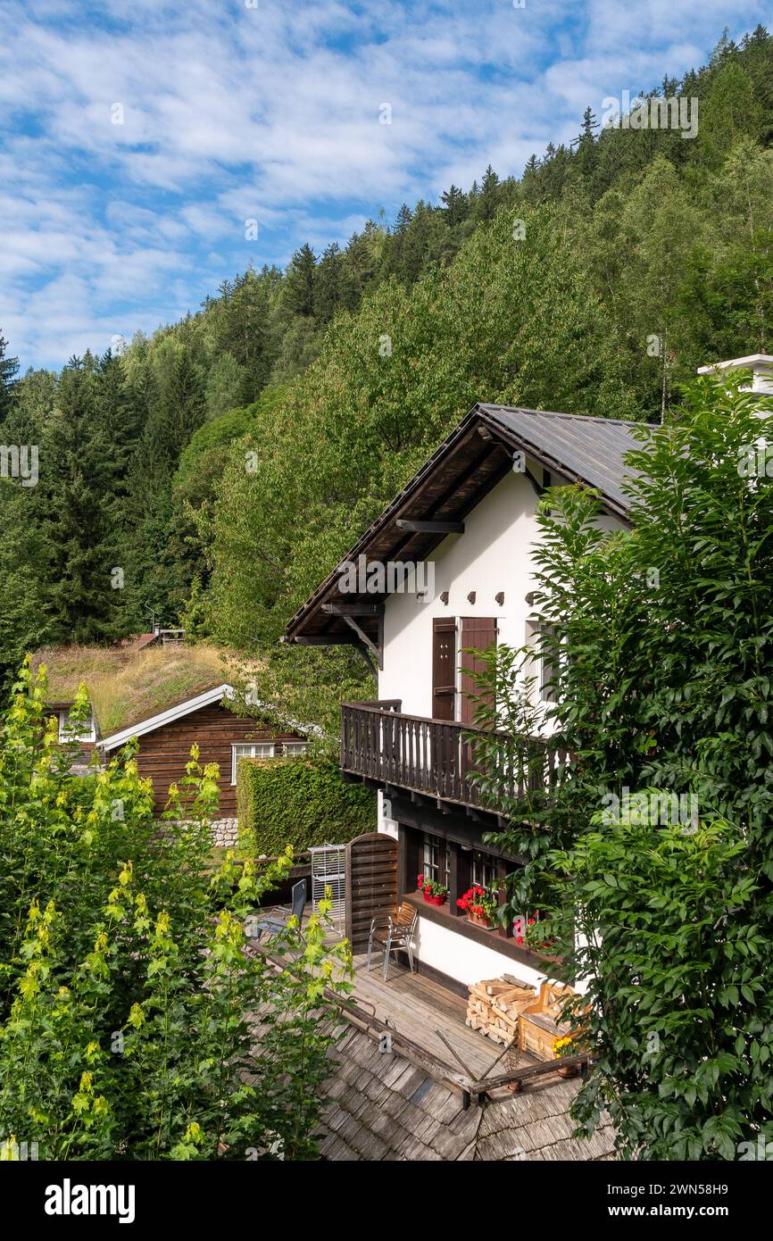 Elevated view of a typical Alpine house with wooden balcony and a green ...