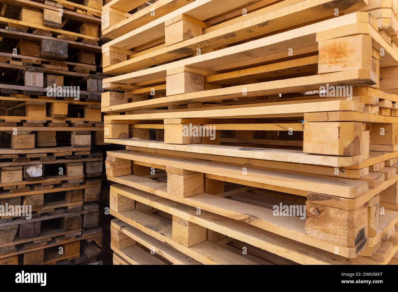 Piles of stacked natural wooden shipping pallets. Outside a big stack ...