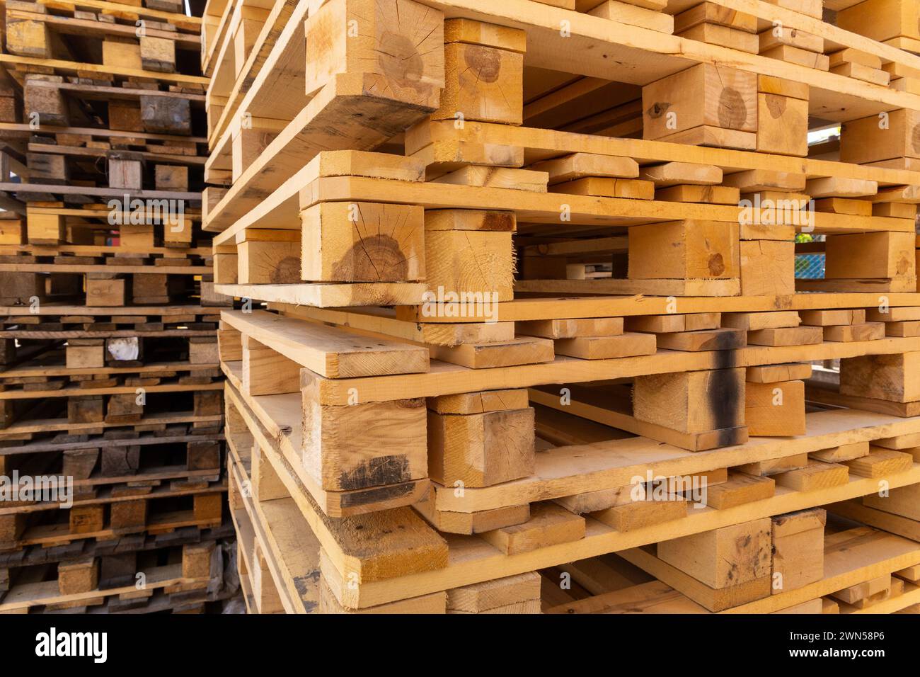 Piles of stacked natural wooden shipping pallets. Outside a big stack ...