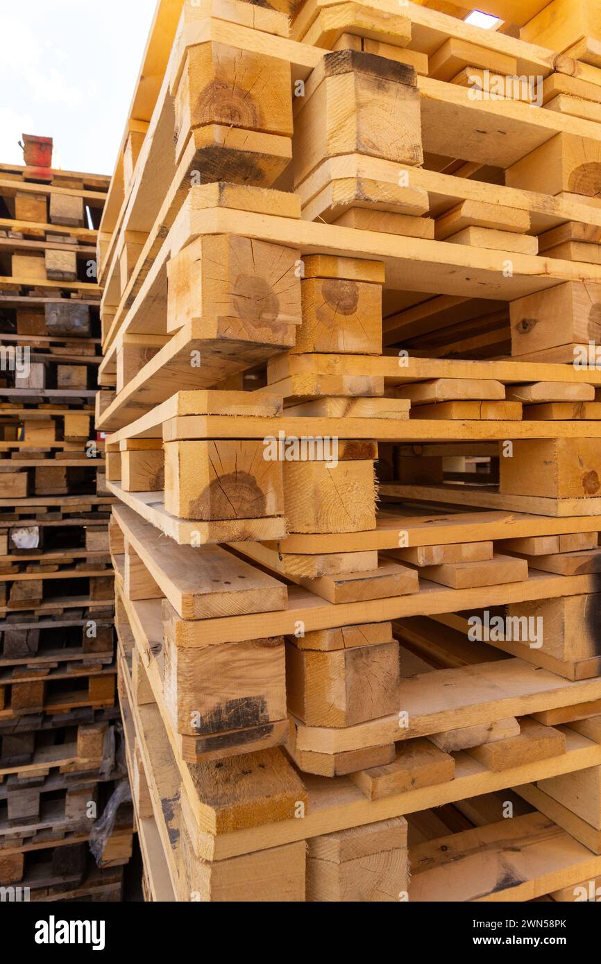 Piles of stacked natural wooden shipping pallets. Outside a big stack ...