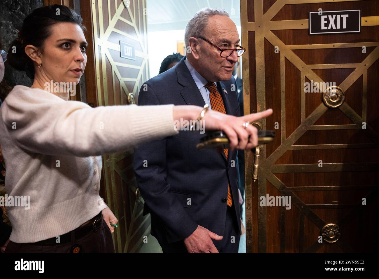 An aide points the way as Senate Majority Leader Chuck Schumer (D-N.Y ...