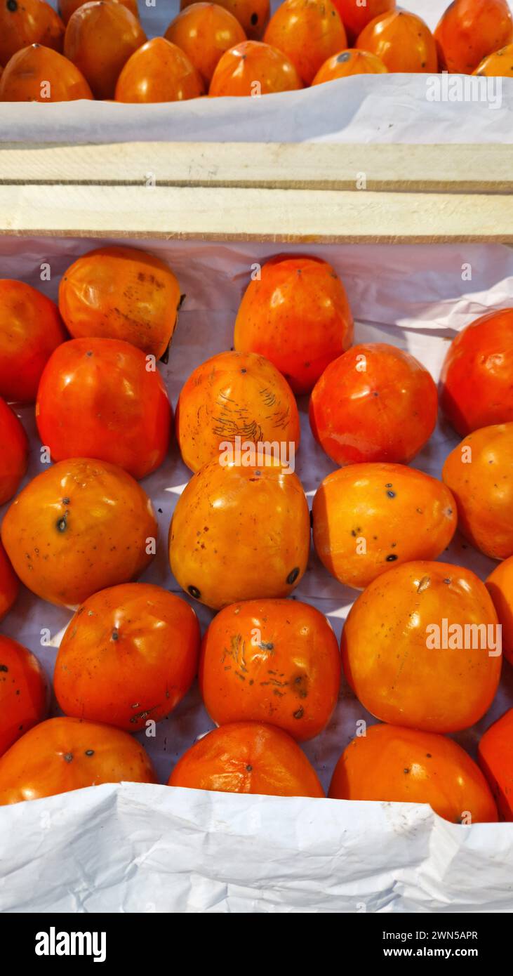 Selling persimmons in a store, close-up. Ripe persimmons are on sale in ...