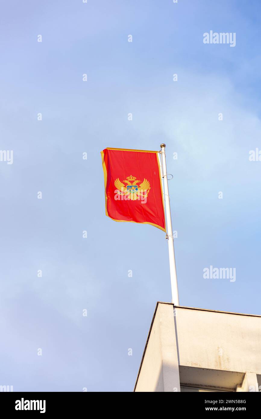 The national flag of Montenegro floating against the blue sky in the ...