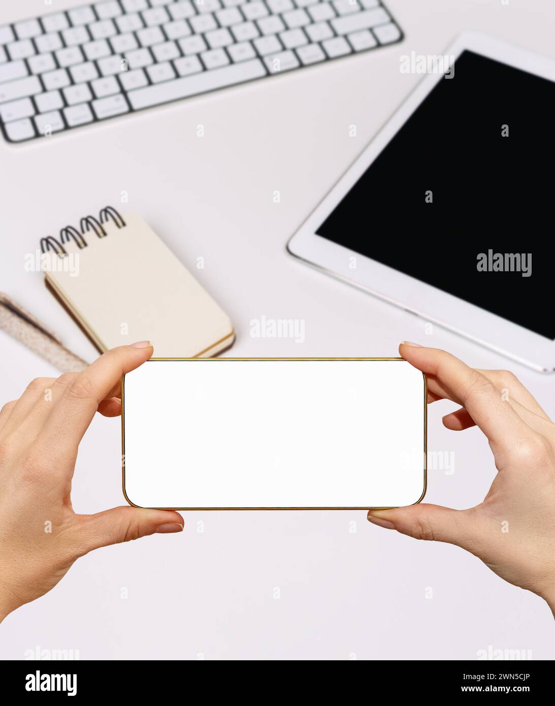 Smartphone with blank screen in female hands in front of office desk ...