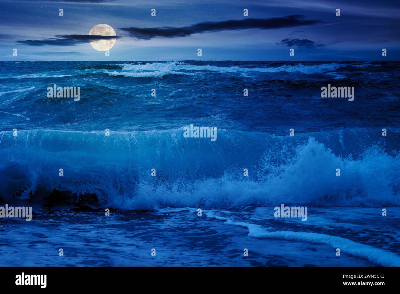 dramatic seascape at night. waves crashing on the beach in full moon ...