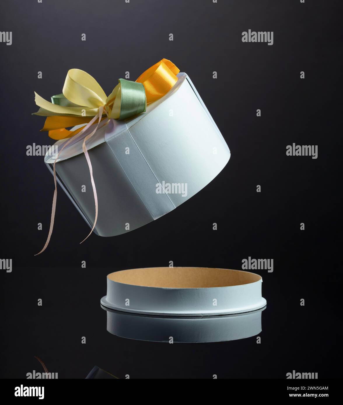 Rounded white cardboard gift box with colorful ribbons. Opened empty ...