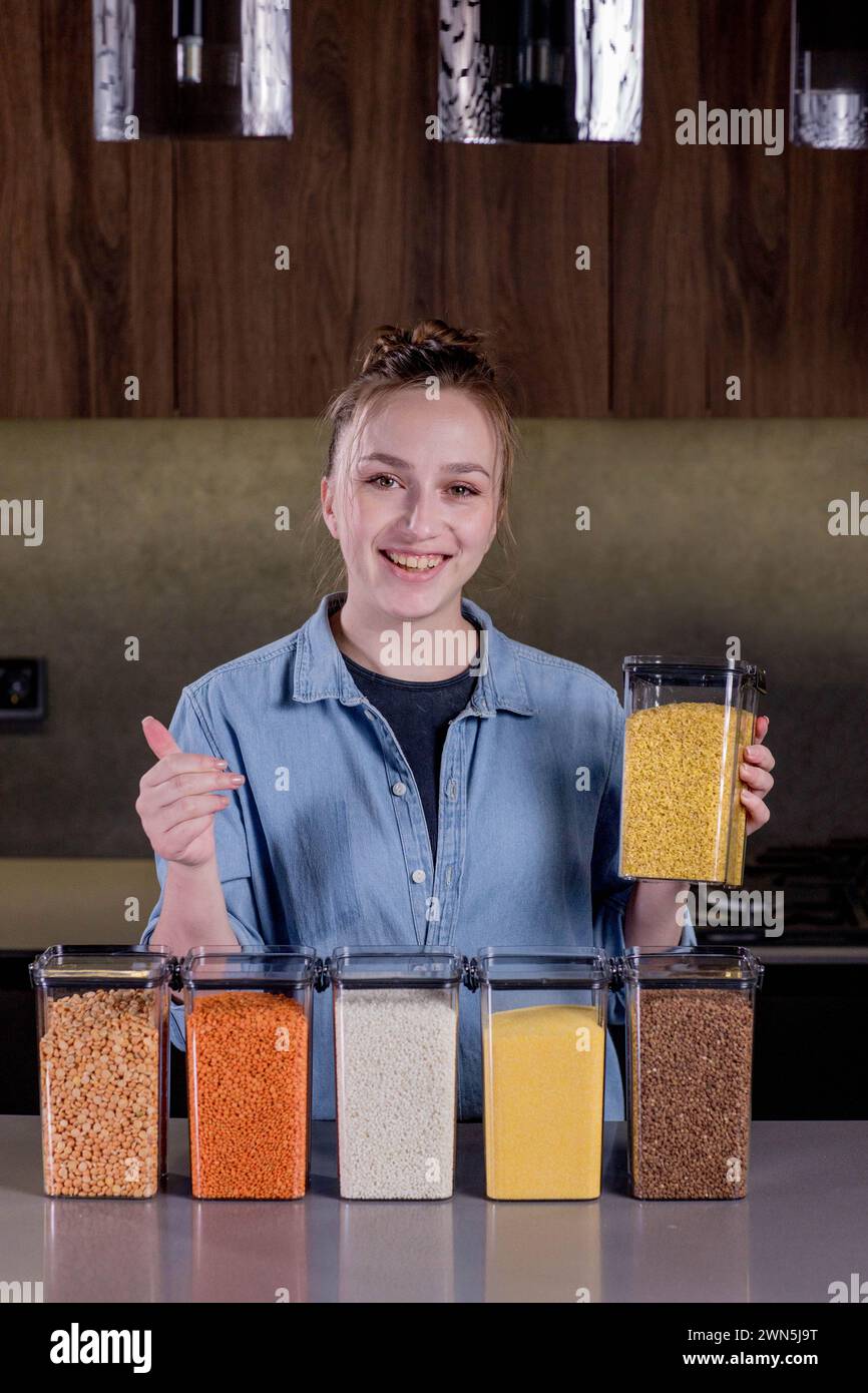 A woman uses containers to organize food in the kitchen. Layout and ...