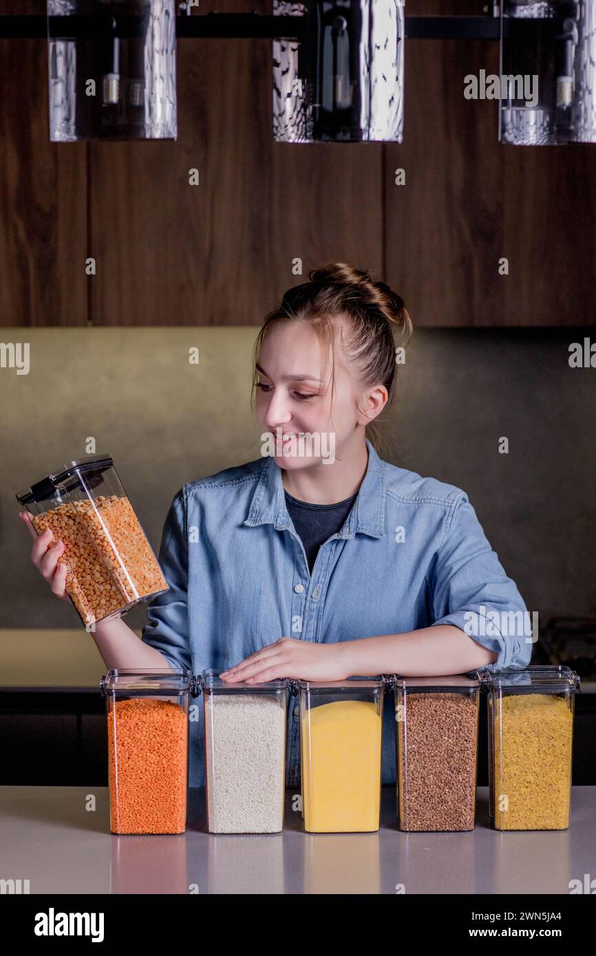 Woman organizing food in the kitchen with containers Stock Photo - Alamy