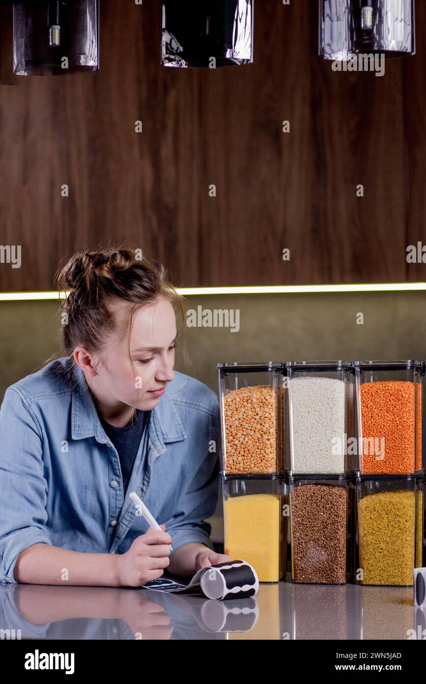 Nice woman organizes the placement of food in plastic cans. Woman signs ...