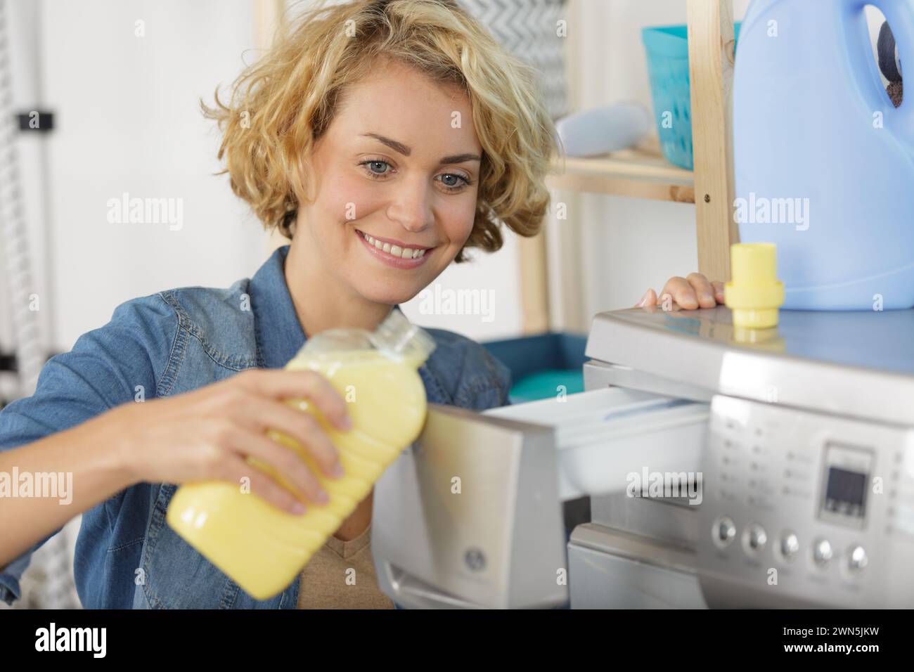 woman adding a fabric softener in washing machine Stock Photo - Alamy