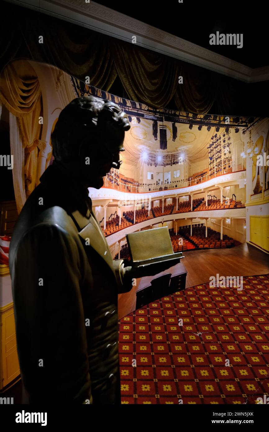 Bronze statue of Abraham Lincoln holding a book with the image of Ford ...