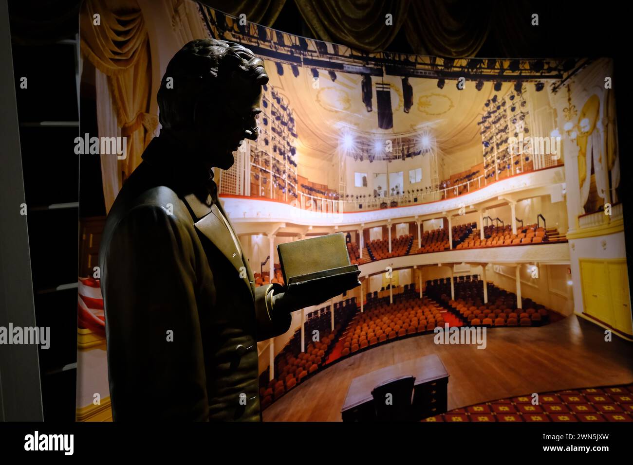 Bronze statue of Abraham Lincoln holding a book with the image of Ford ...