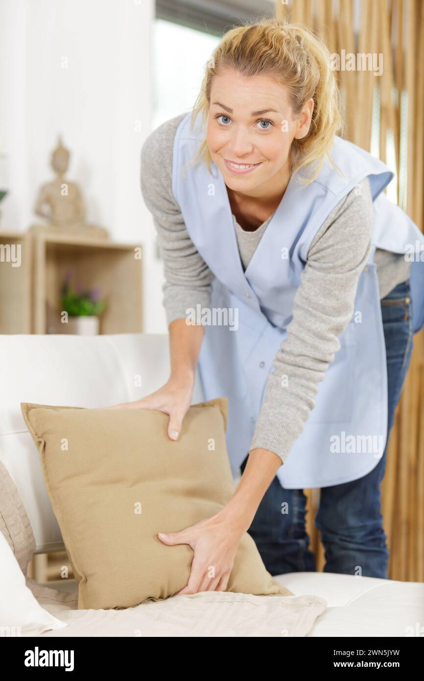housewife tidy up sofa couch at home Stock Photo - Alamy