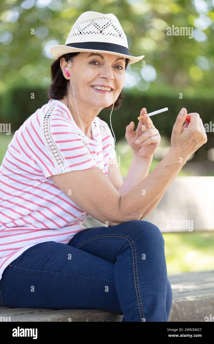 senior woman lighting up a cigarette outdoors Stock Photo - Alamy