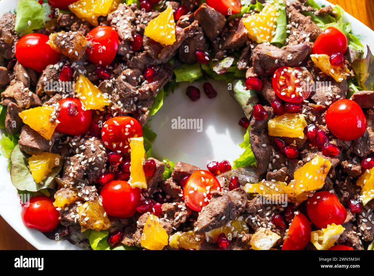 Warm salad in shape of a ring with chicken liver, cherry tomatoes ...