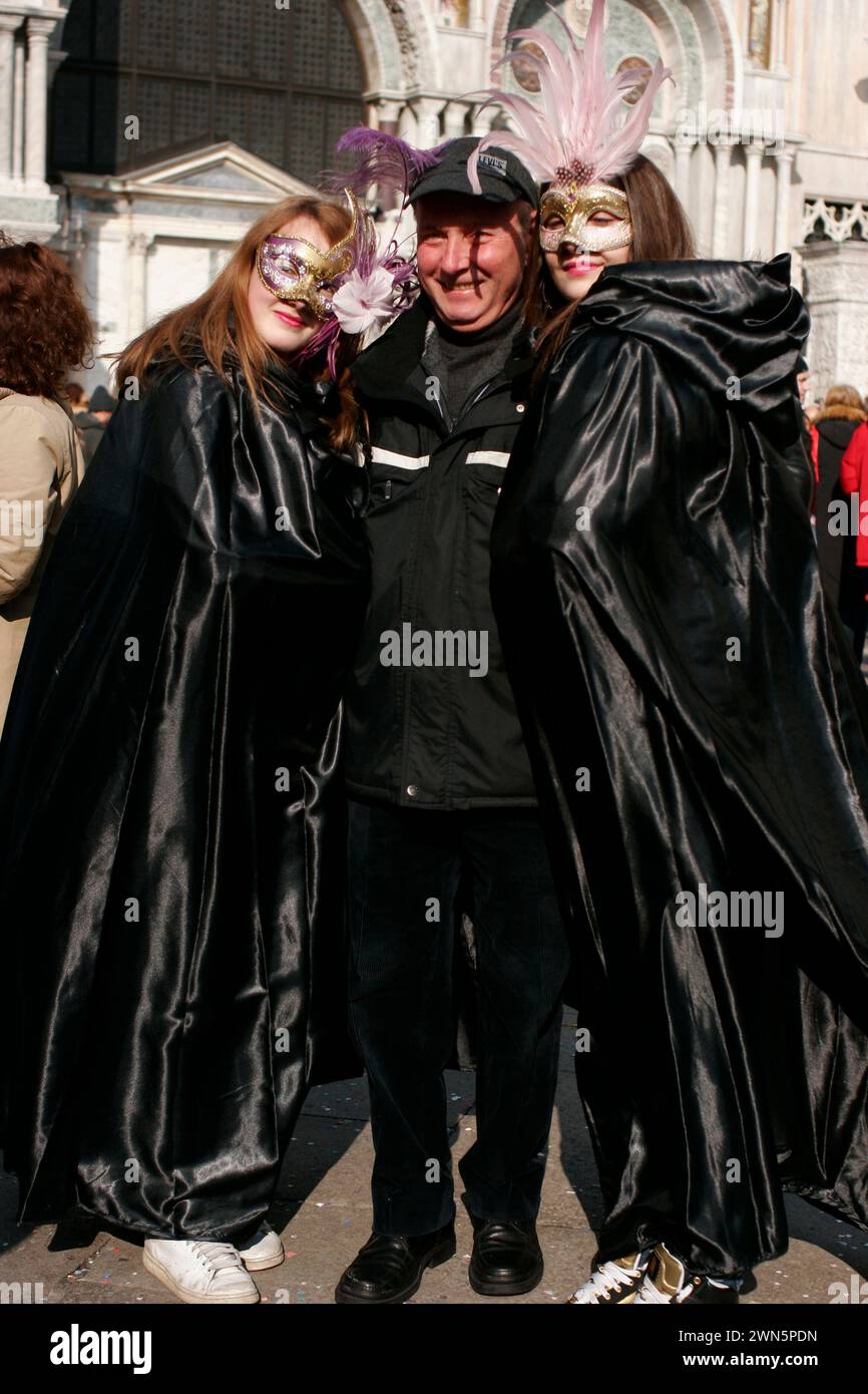 Happy man between two young girls at the Venice Carnival in Italy Stock ...
