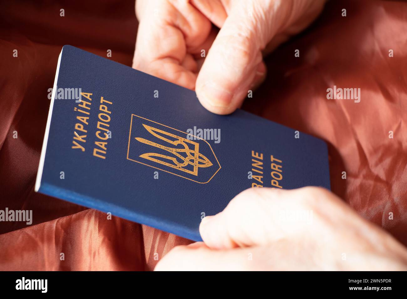 Hands Of An Old Woman Hold A Ukrainian Foreign Passport Close Up