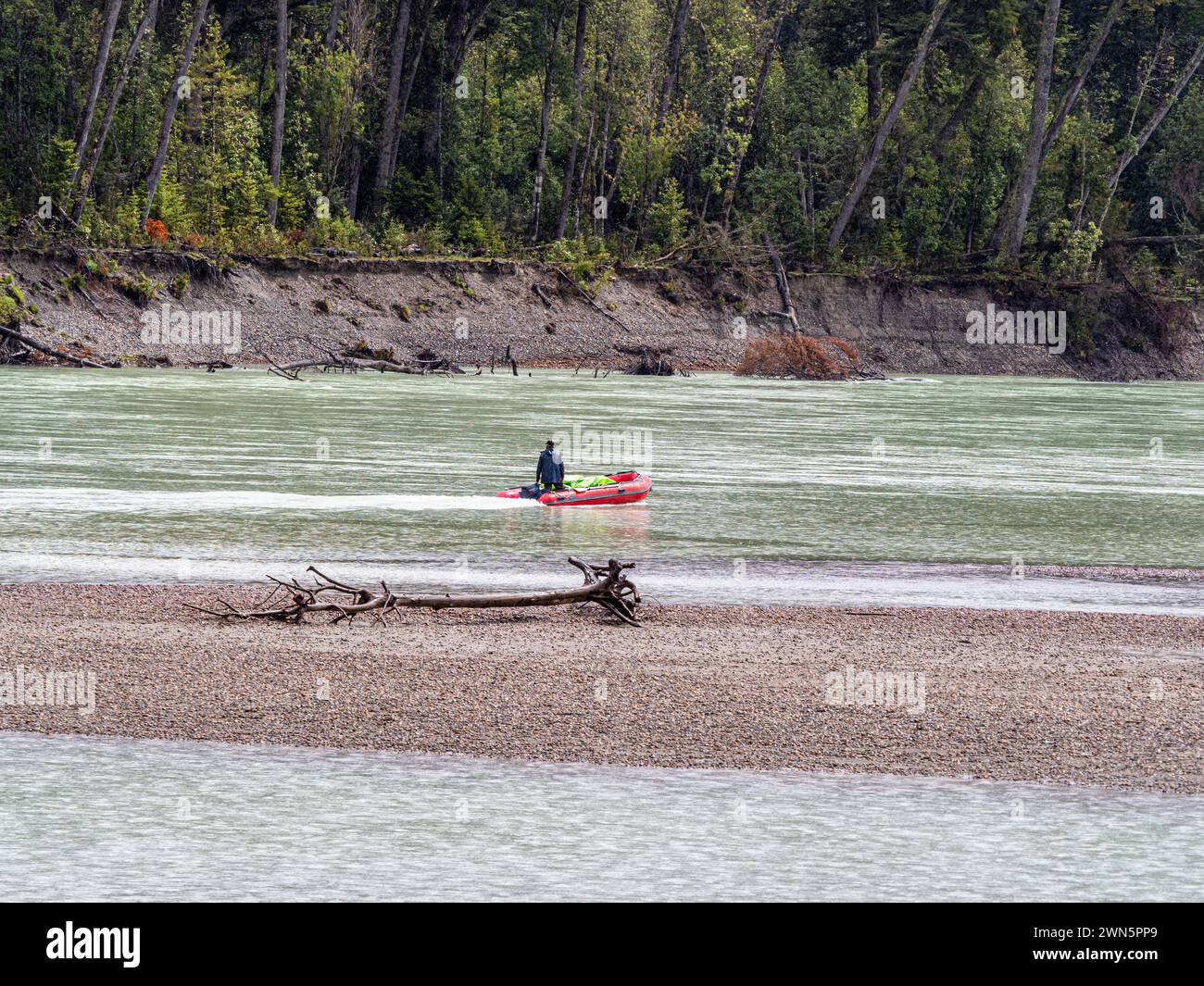 Man crossing river Rio Baker in a small boat, upstream of village ...