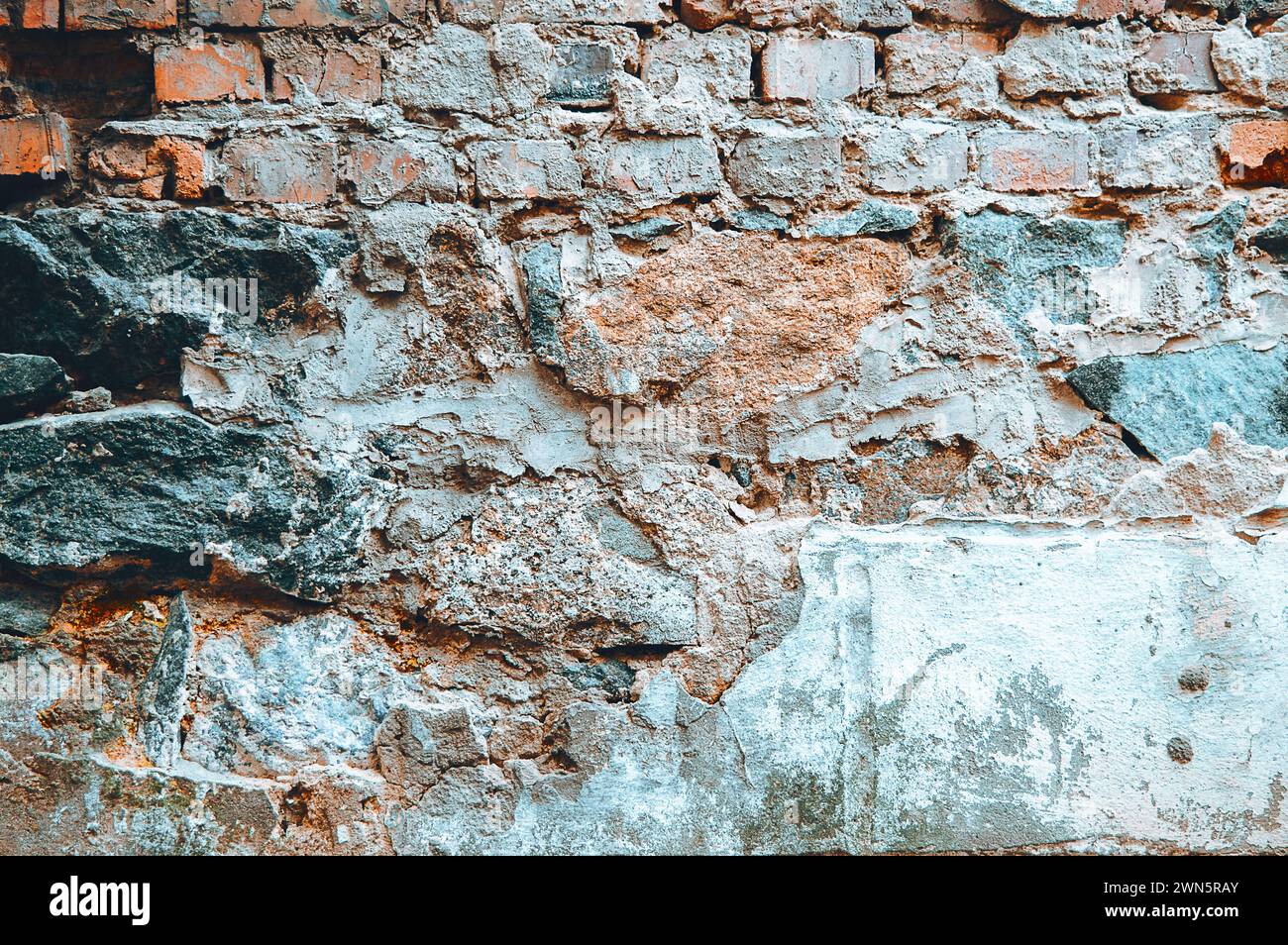 Red brick wall in the cracks. Shattered brick wall close up. Old ruined ...
