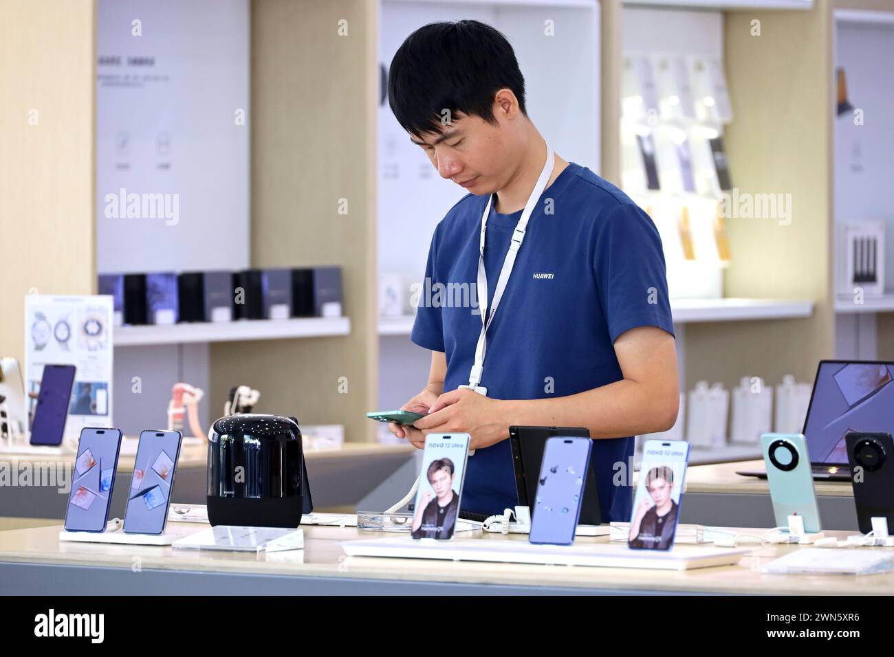 Salesman with mobile phone waiting customers in smartphones store ...