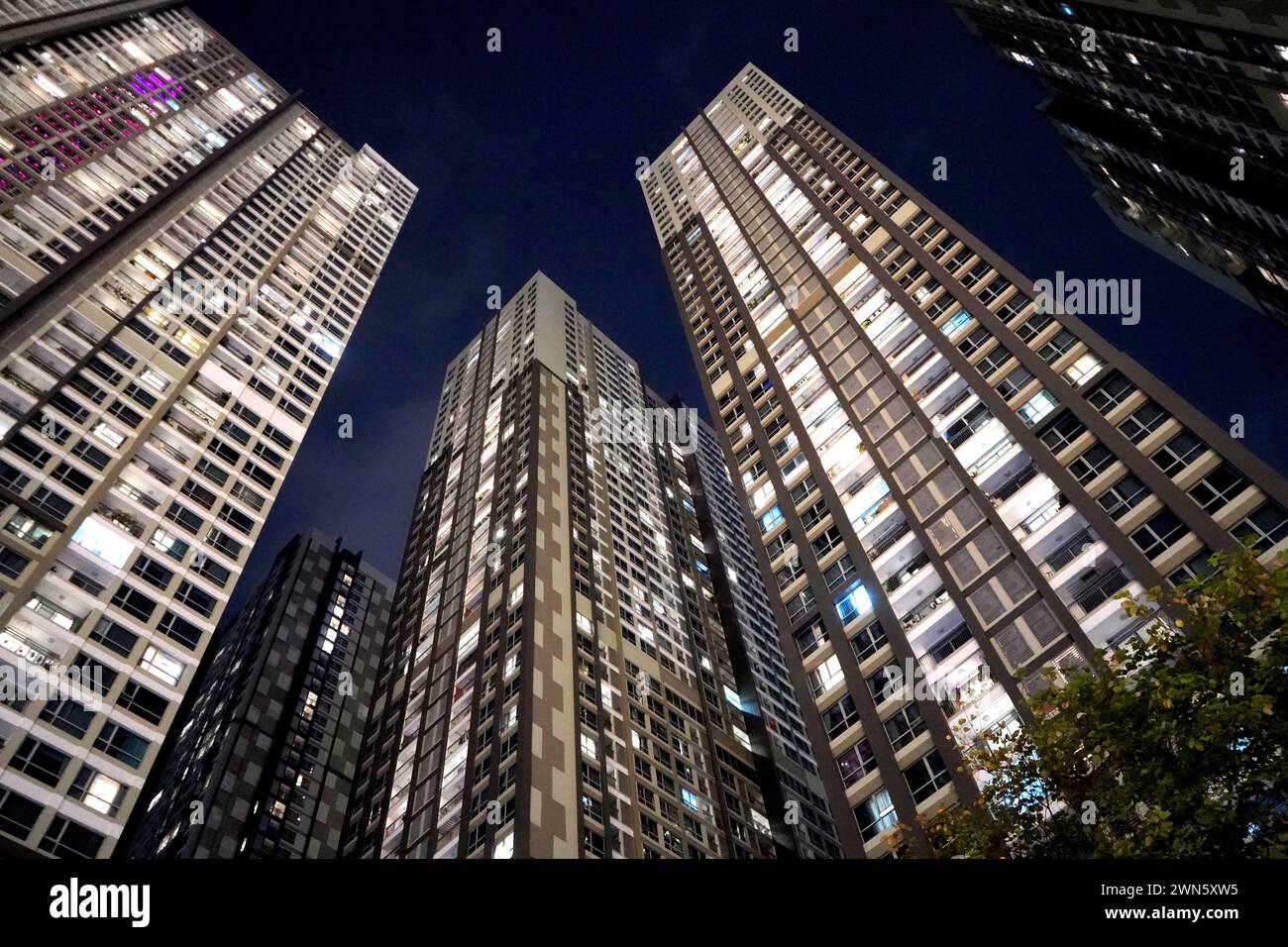Low angle view of modern skyscrapers at night, towering above Stock ...