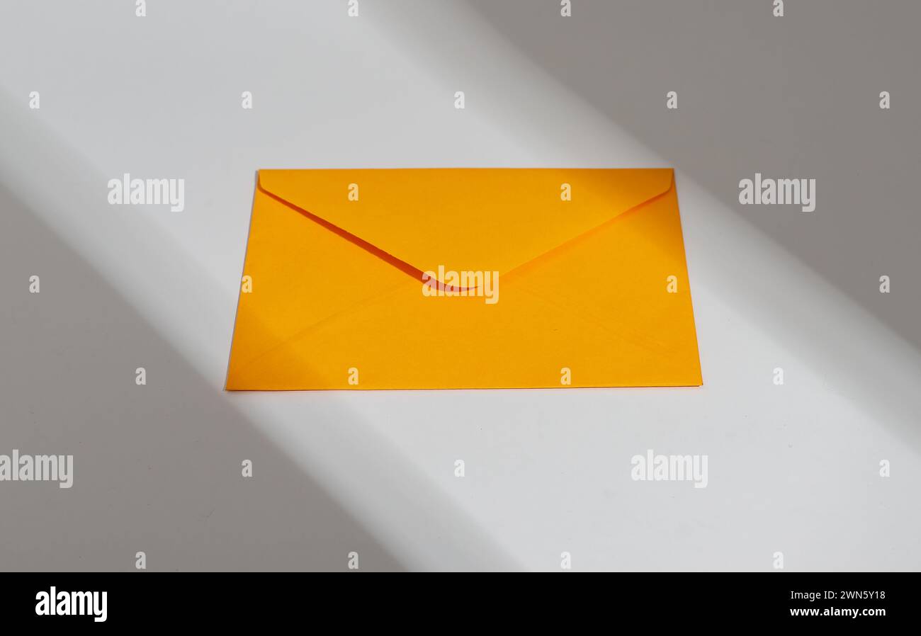 Bright orange envelope, paper letter, light beam and shadow Stock Photo ...