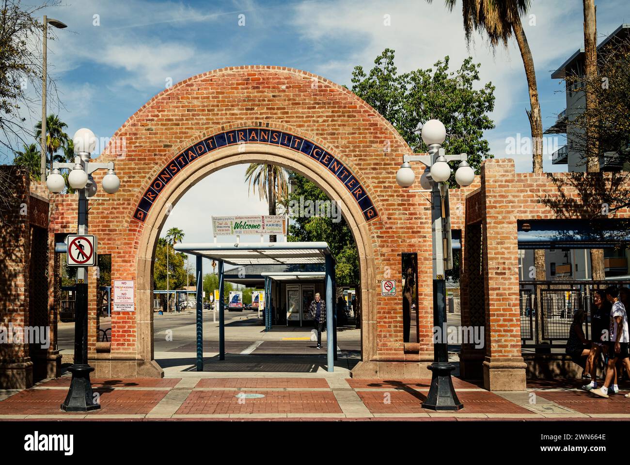 A sidewalk view of a red brick arched entry way with signage for ...