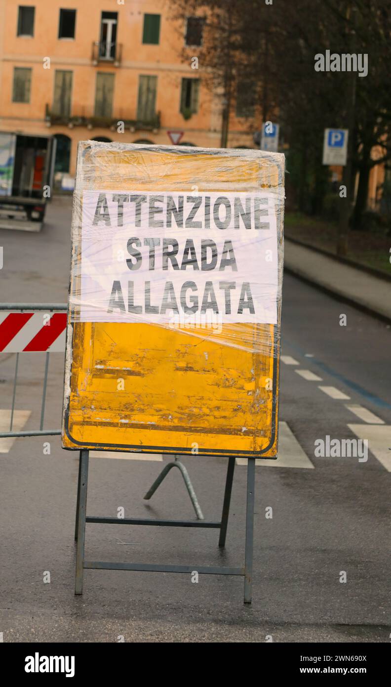 Large warning sign with big text ATTENZIONE STRADA ALLAGATA in italian ...