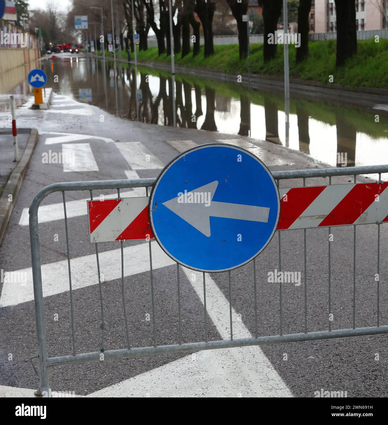 road sign with detour arrow due to the road being flooded after the ...