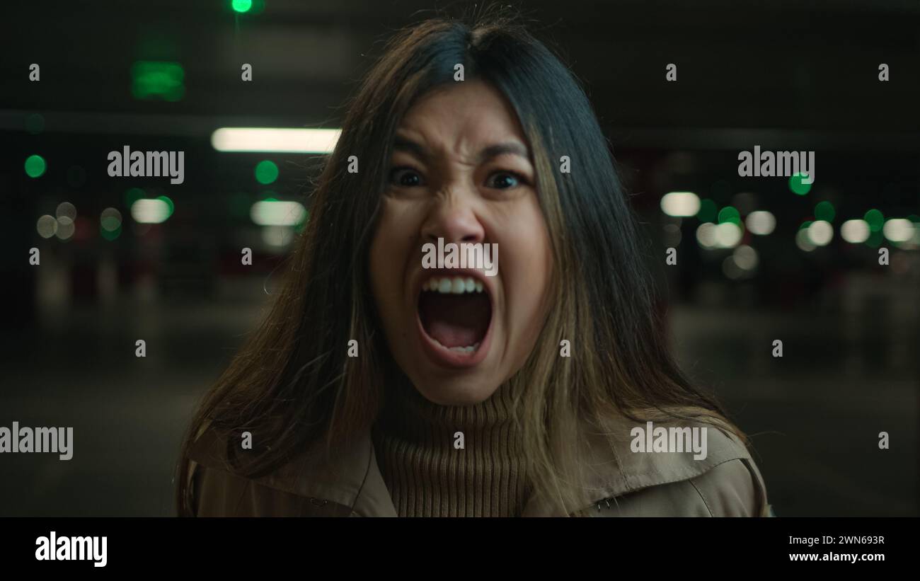 Mad angry crazy Asian korean chinese japanese girl shout in car parking furious woman annoyed ...