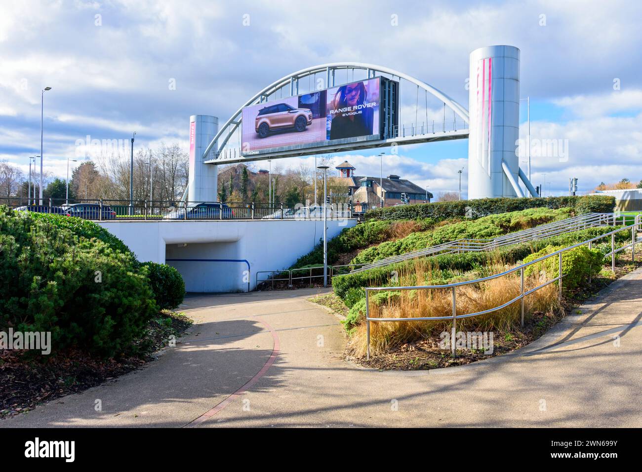 Pedestrian underpass and arched advertising hoarding over a roundabout ...